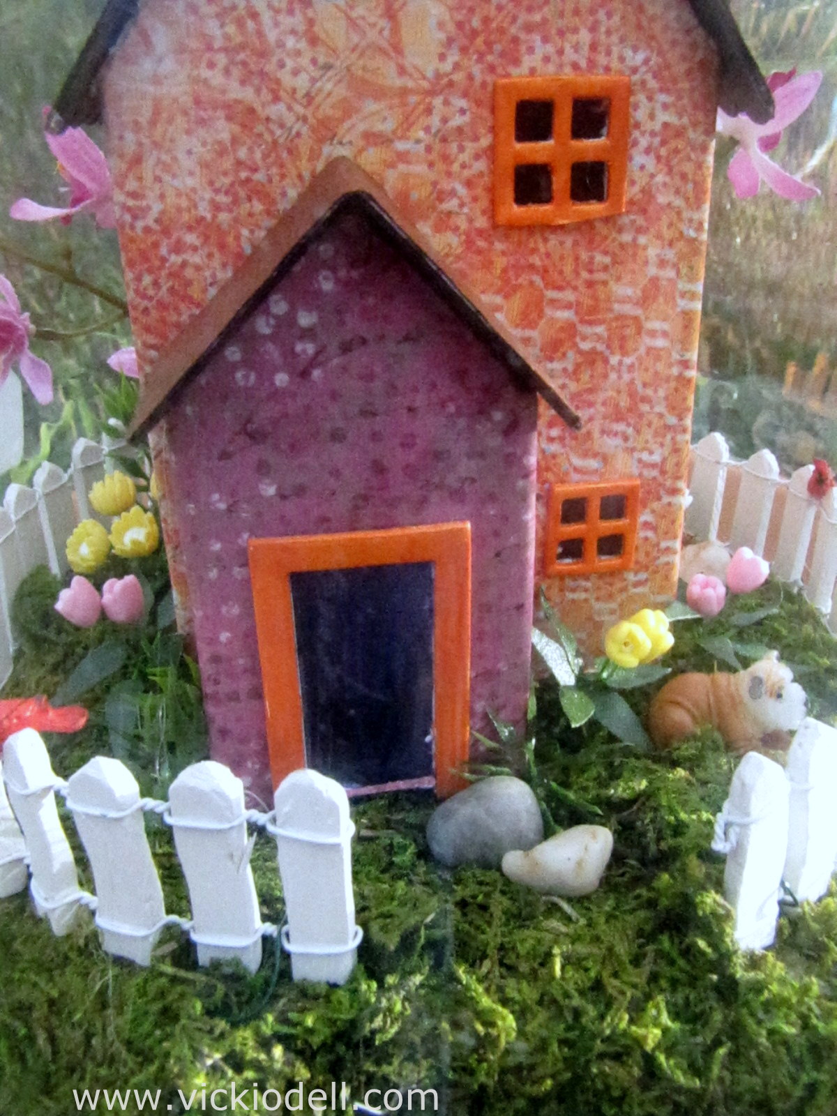 A Miniature House and Garden Under a Cloche